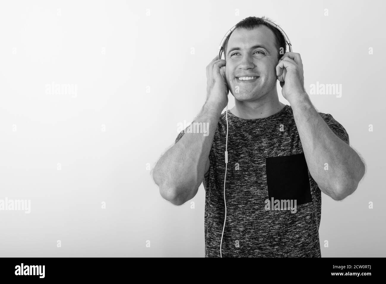 Studio shot of young happy muscular man smiling while thinking and ...