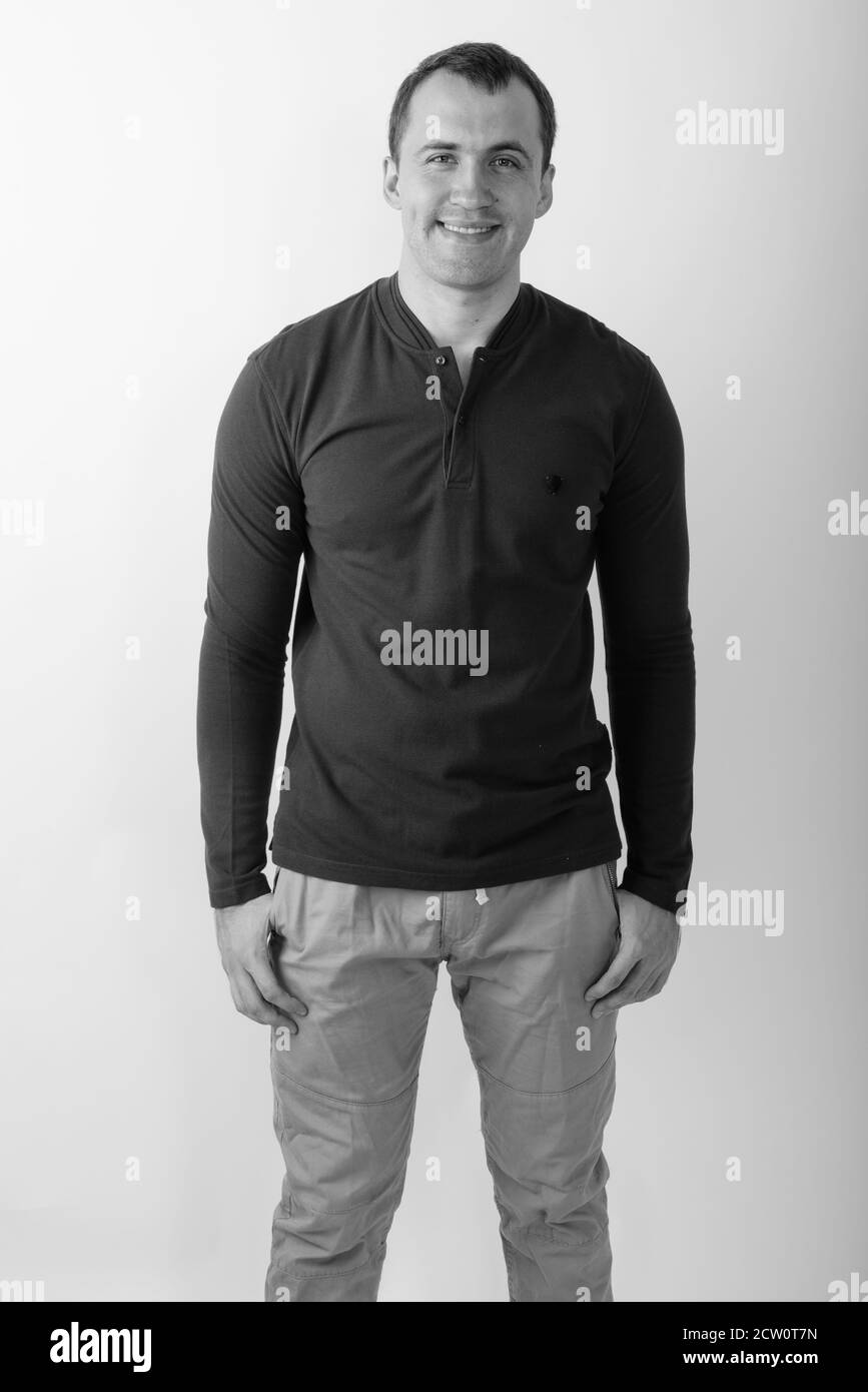 Studio shot of young happy muscular man smiling and standing against ...