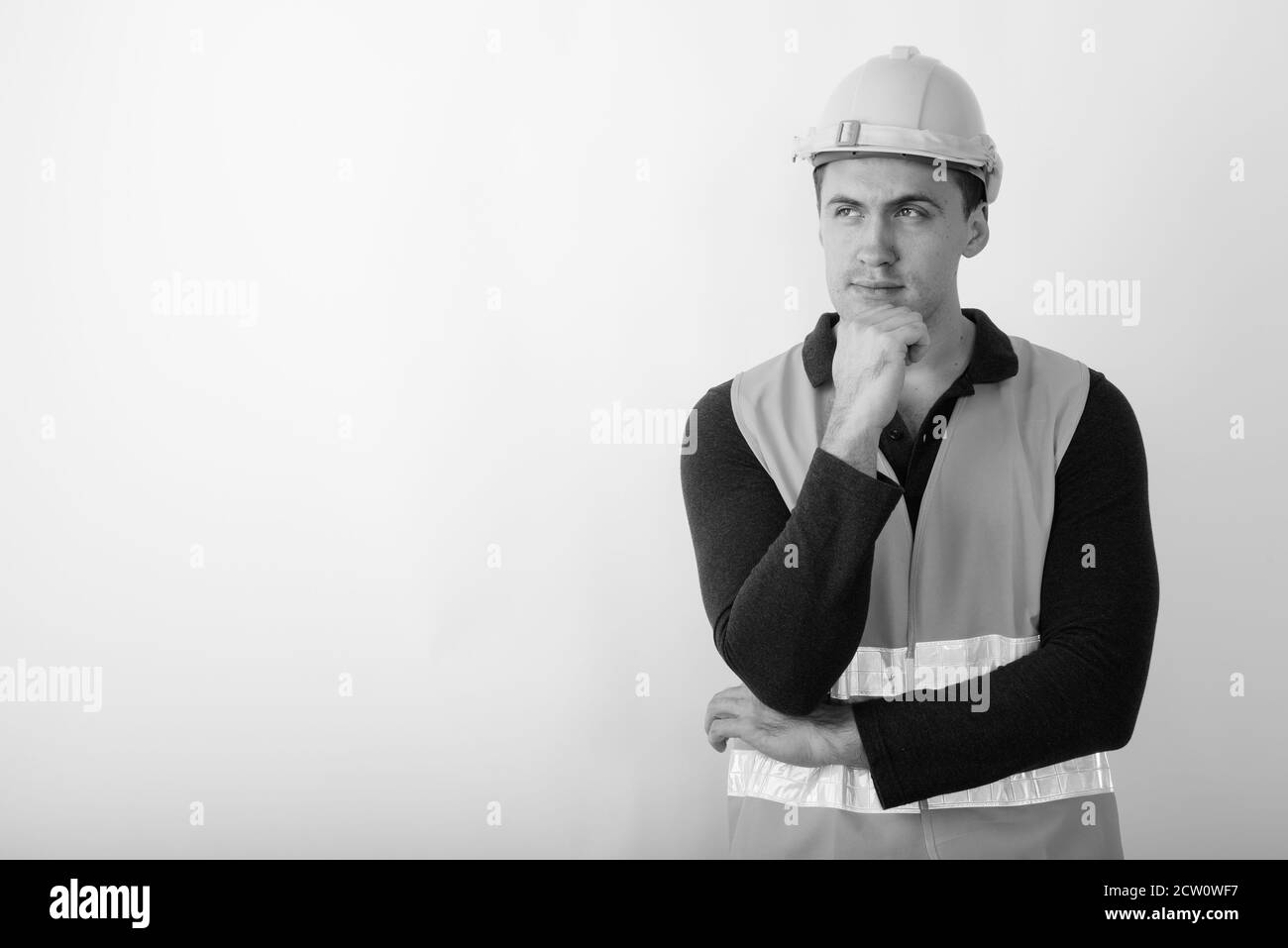 Studio shot of young muscular man construction worker thinking against ...