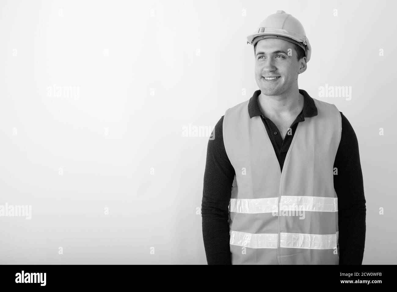 Studio shot of young happy muscular man construction worker smiling and ...