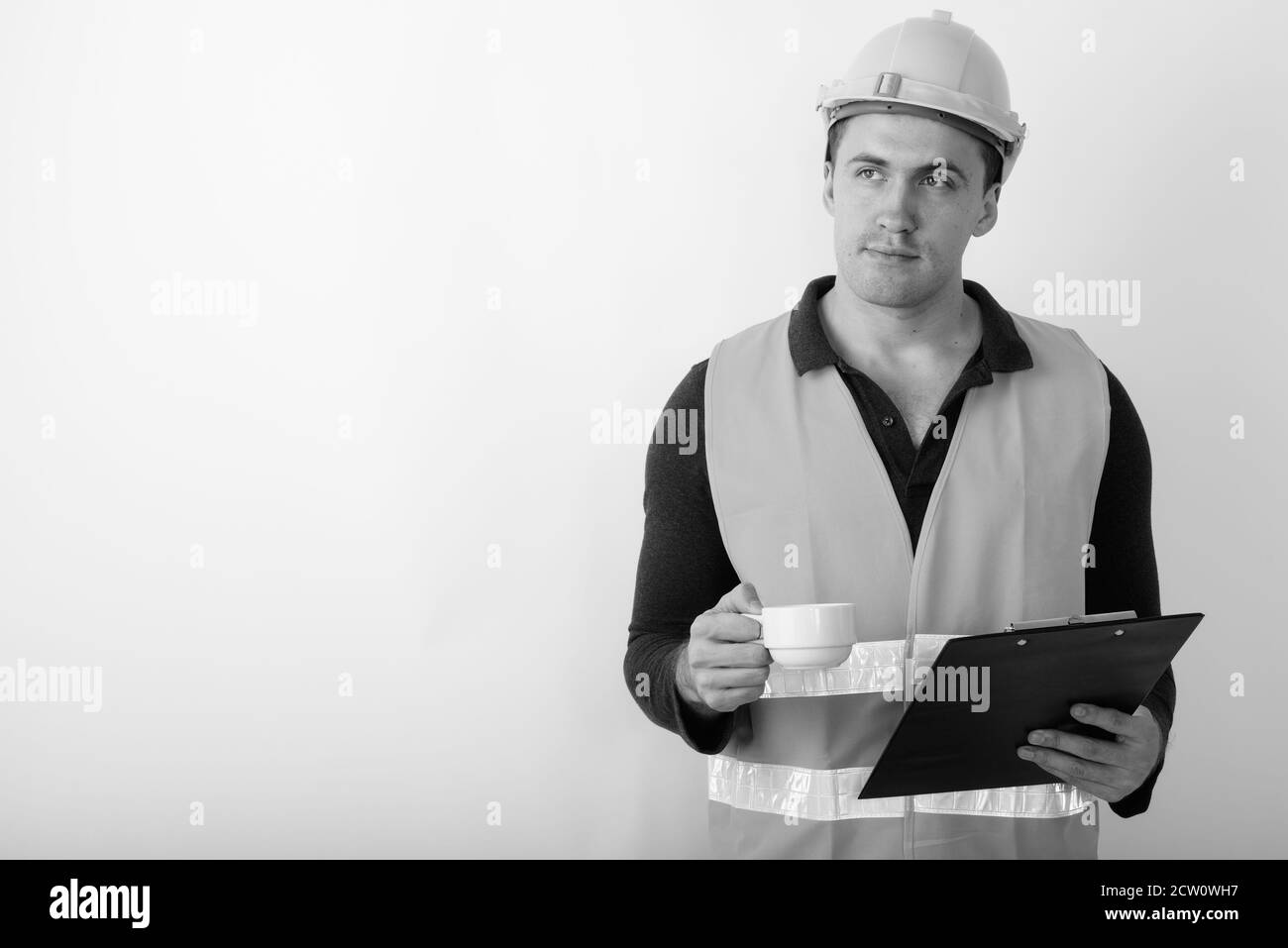 Studio shot of young muscular man construction worker thinking while ...
