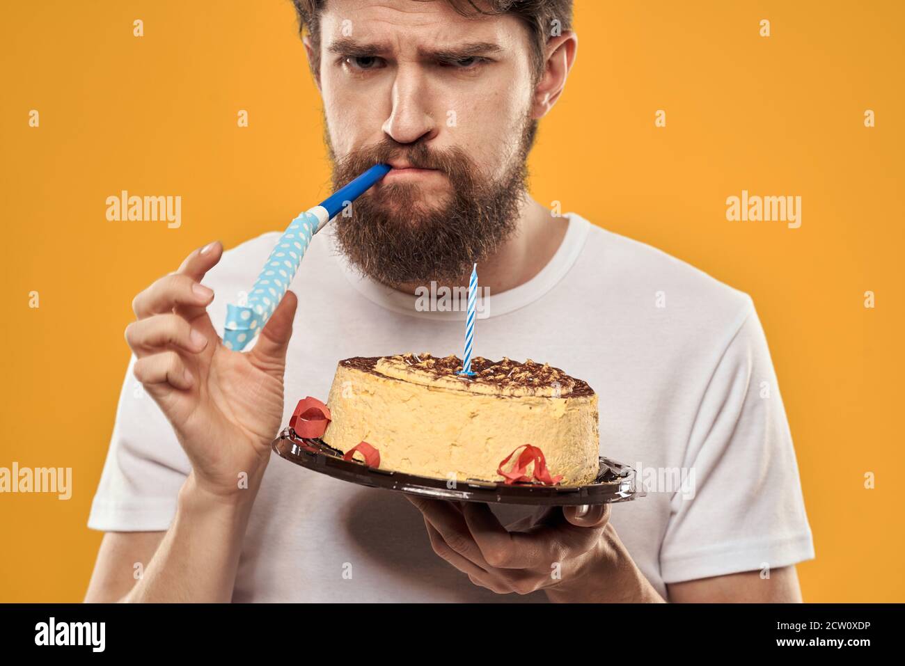A bearded man with a cake and in a cap celebrating his birthday Stock ...