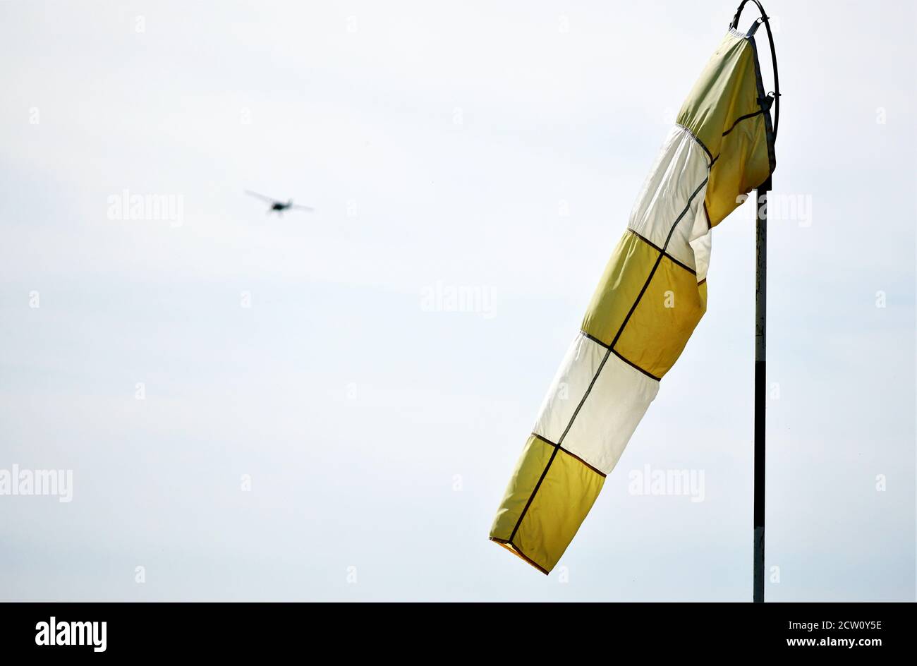 Closeup of a yellow and white windsock floating in the air during ...