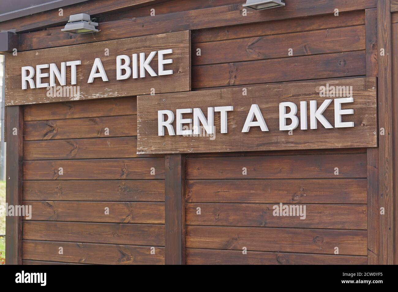 Rent a bike sign at wooden cabin Stock Photo - Alamy