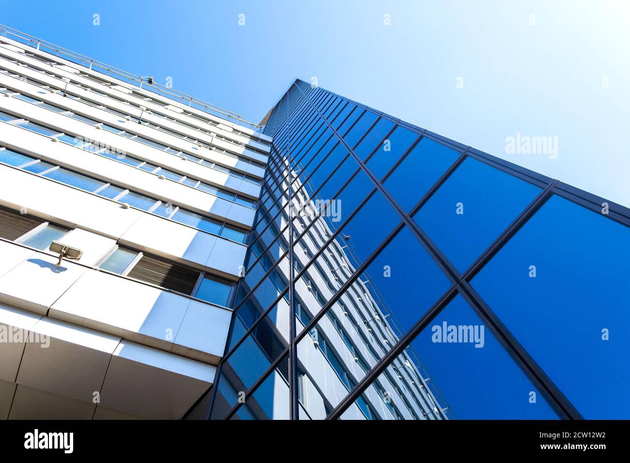 Glass modern skyscraper building opposite blue sky in perspective view ...