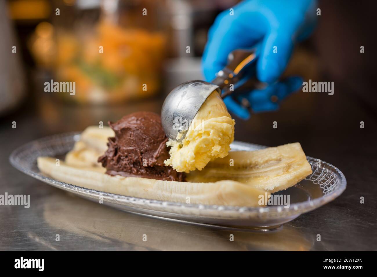 Preparation of artisanal Italian Banana split with ice cream, whipped ...