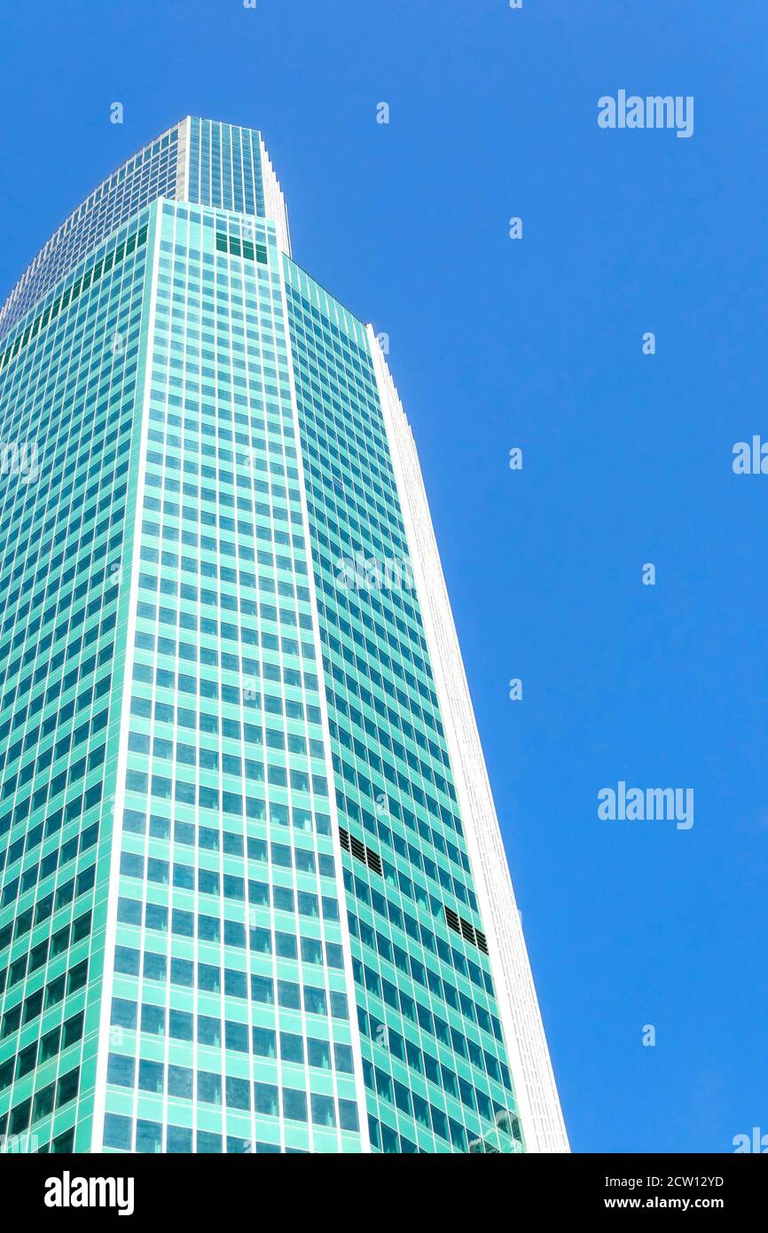 Glass modern skyscraper building opposite blue sky in perspective view ...