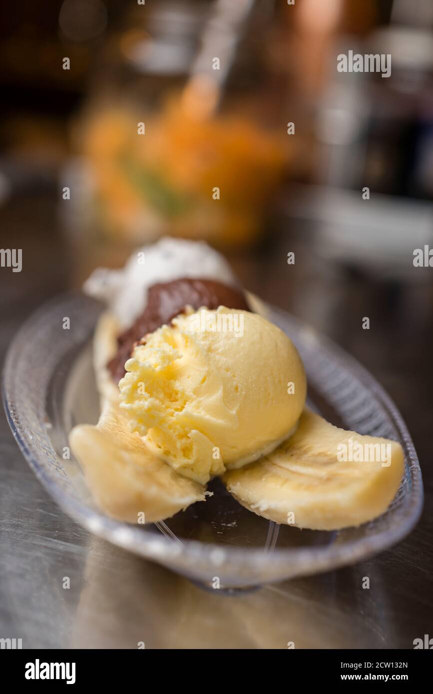 Preparation of artisanal Italian Banana split with ice cream, whipped ...