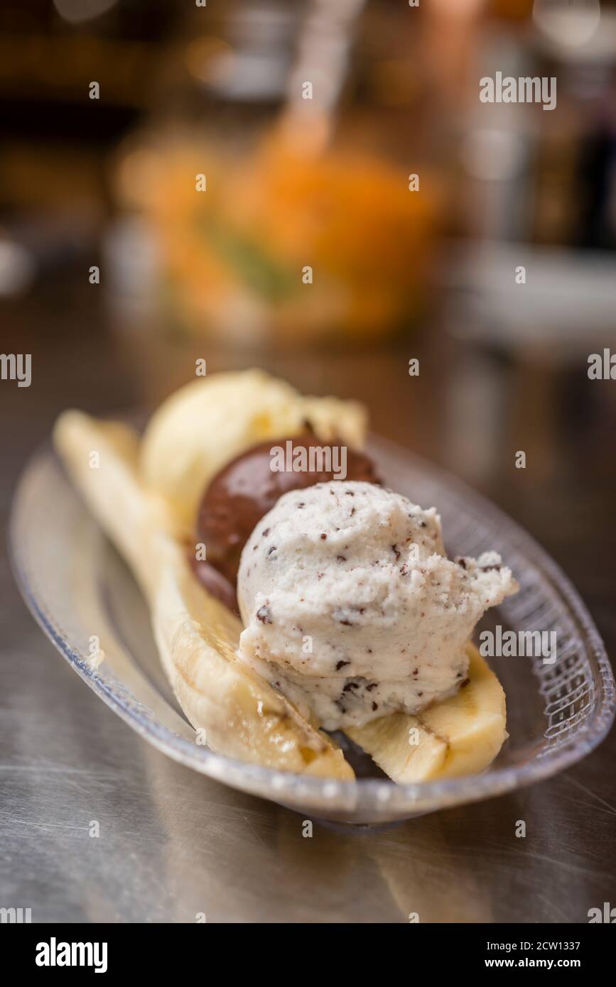 Preparation of artisanal Italian Banana split with ice cream, whipped ...