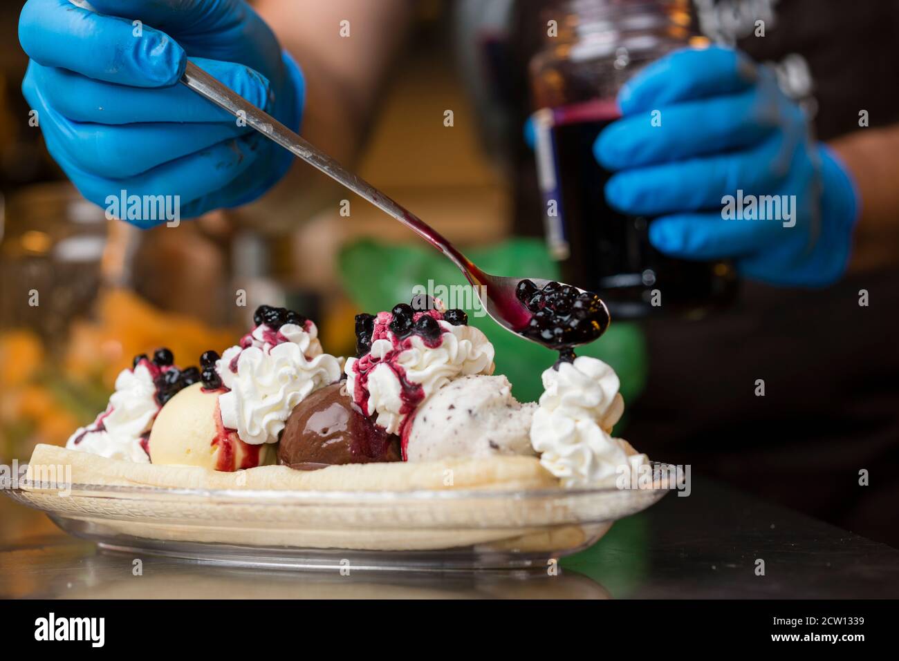 Preparation of artisanal Italian Banana split with ice cream, whipped ...