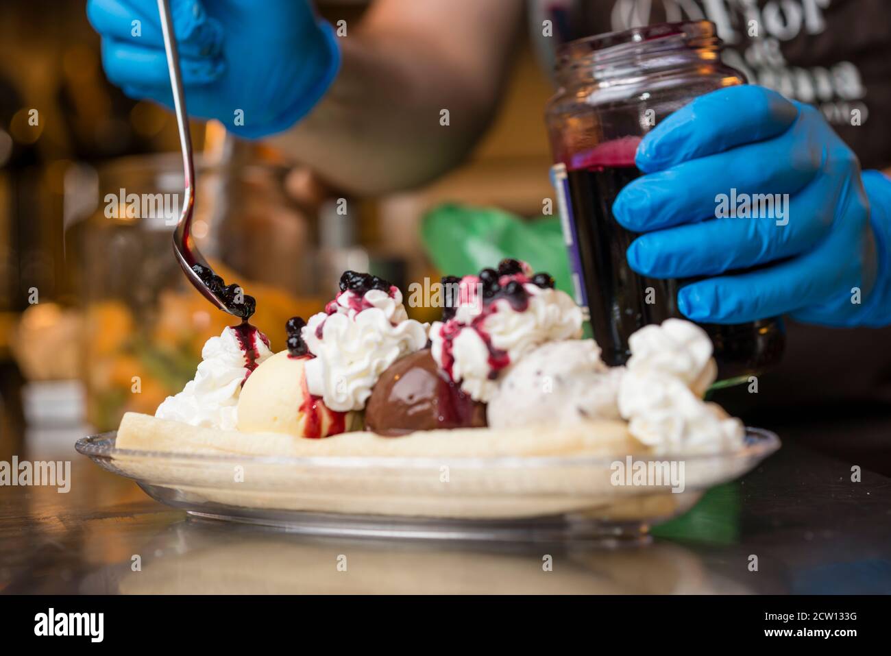 Preparation of artisanal Italian Banana split with ice cream, whipped ...