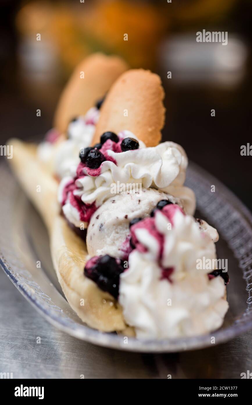 Preparation of artisanal Italian Banana split with ice cream, whipped ...