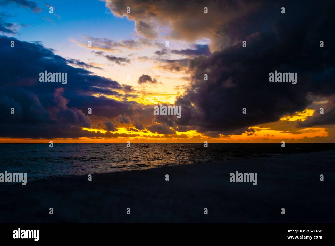 Sun through storm clouds over the sea hi-res stock photography and ...