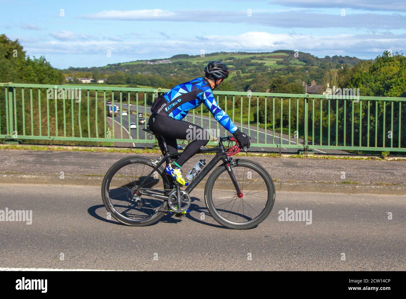 Male cyclist riding Ribble road bike on countryside route crossing ...
