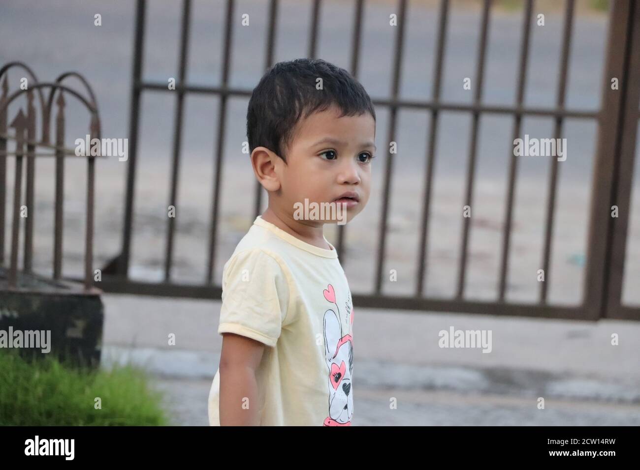 Cute little baby boy standing outside and looking with worries in the ...