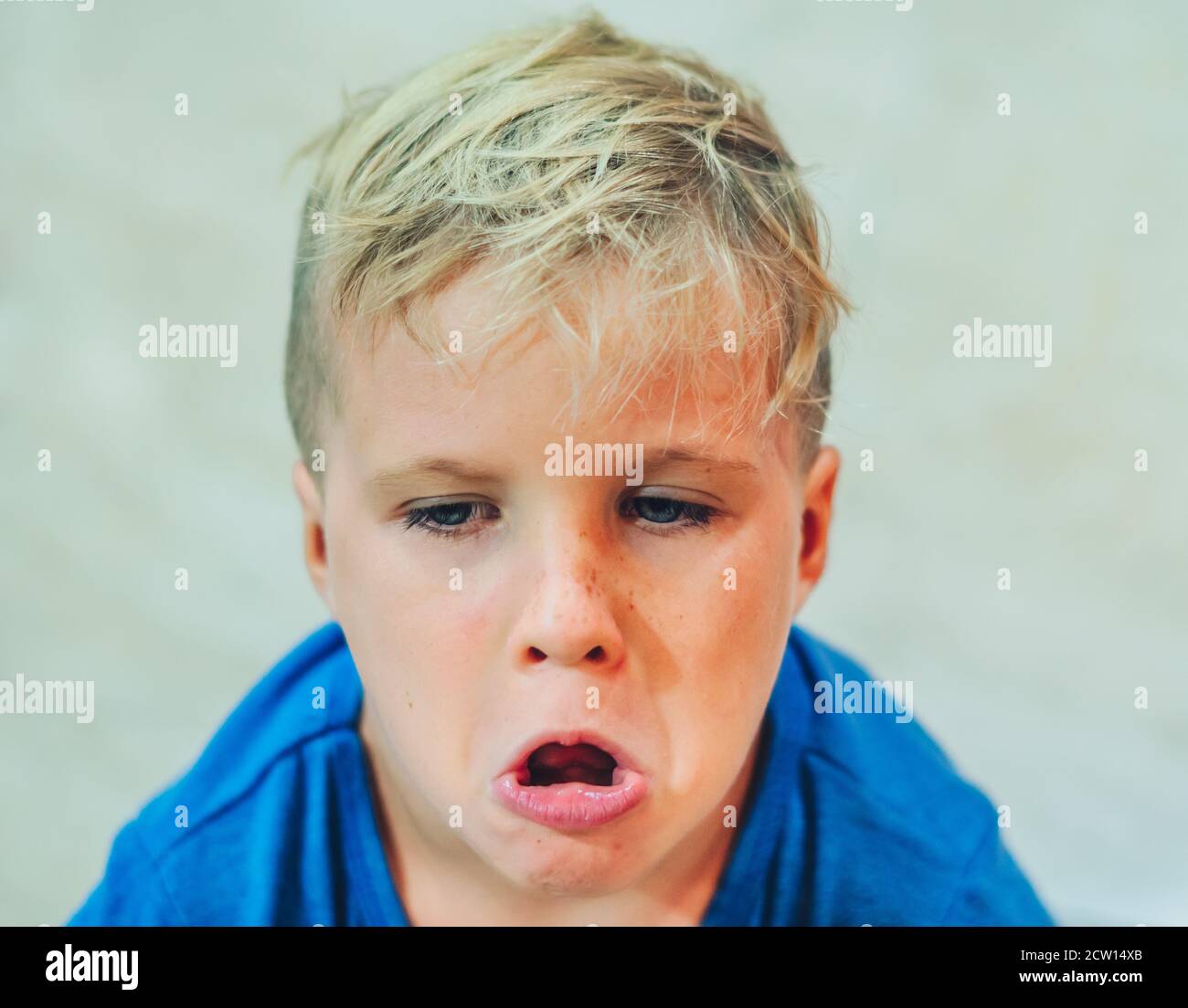 Close up portrait opened dissatisfied mouth freckled blond boy artistic ...
