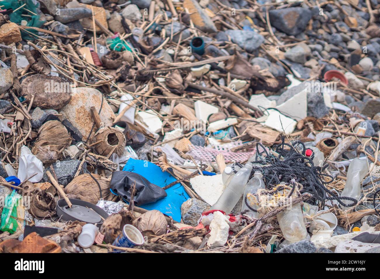 Spilled garbage on sea shore stones gray gravel. Empty used dirty waste ...