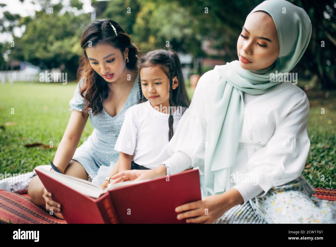 Friends teaching kids in the park Stock Photo - Alamy
