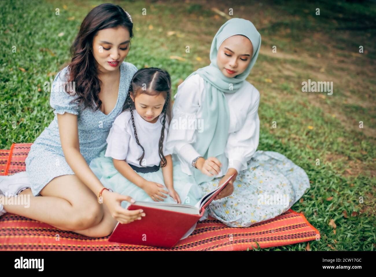 Friends teaching kids in the park Stock Photo - Alamy