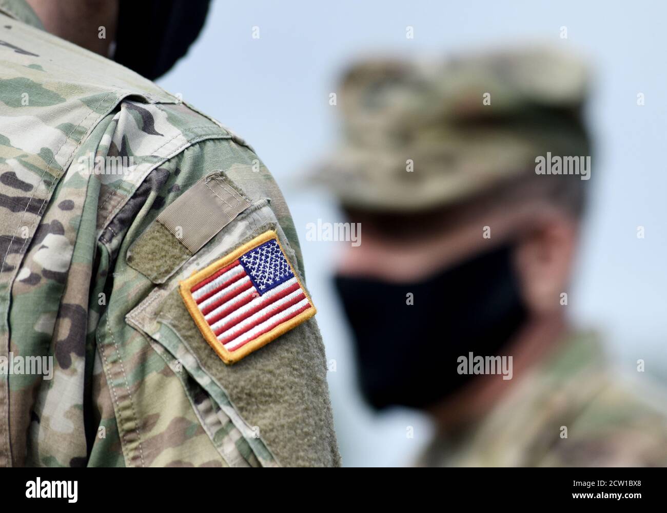 American flag on soldier arm and US soldiers wearing protective face ...