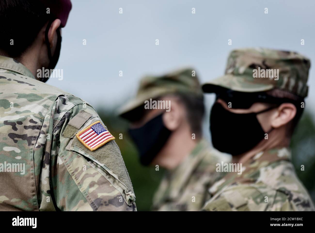 American flag on soldier arm and US soldiers wearing protective face ...