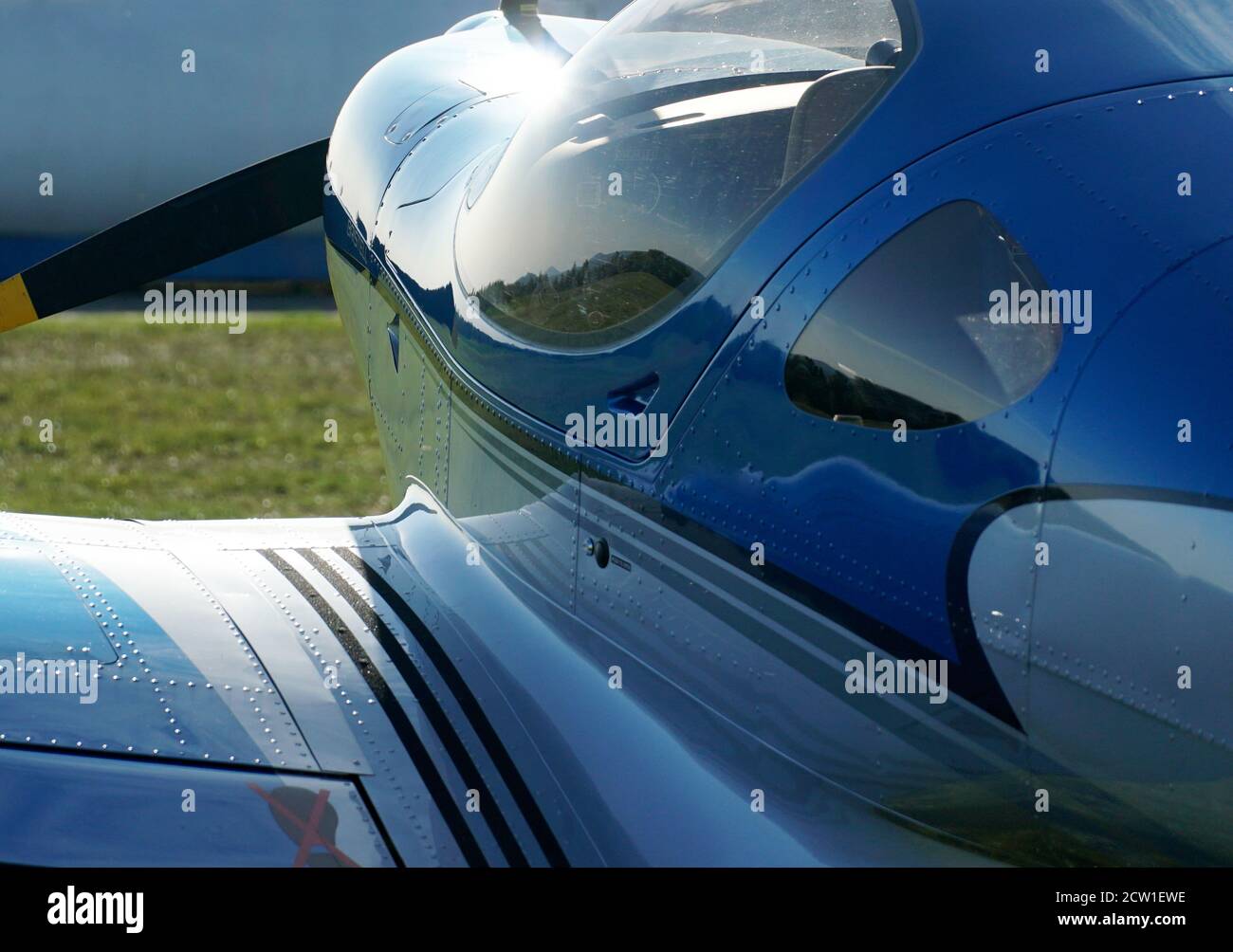 Closeup of a blue single-engine aircraft in a field during daylight ...