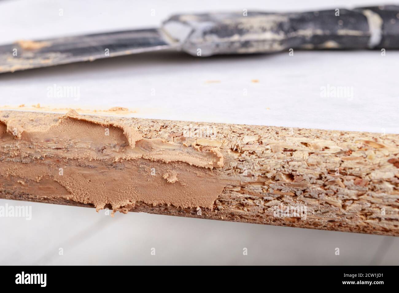 Filling chipboard with putty in a carpentry workshop. Small carpentry ...