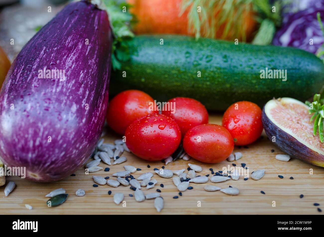 Assortment of fresh vegetables and fruits on a wooden board. Close up ...