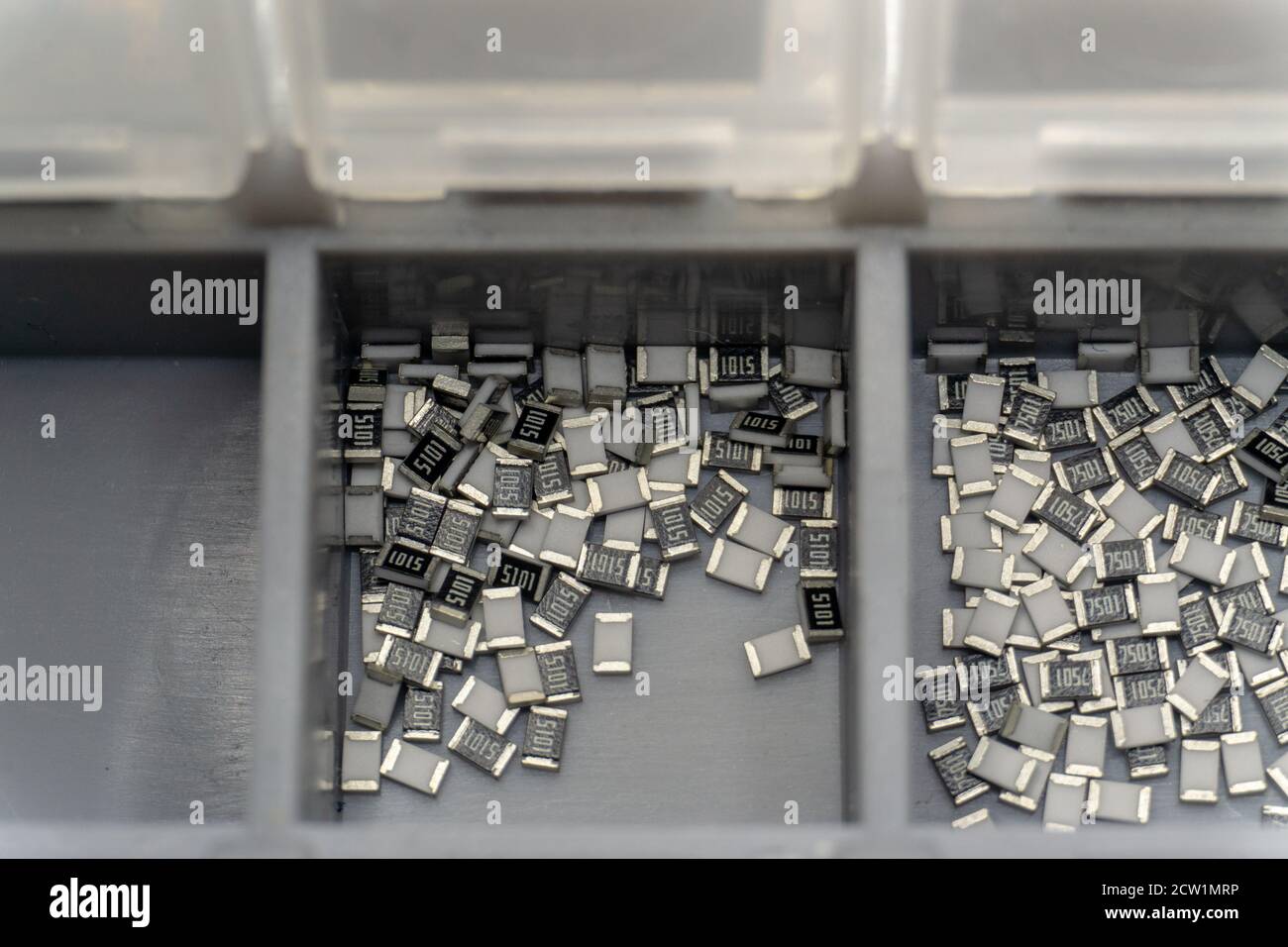 Grey scattered microscopic SMT surface mount chip resistors sorted in ...