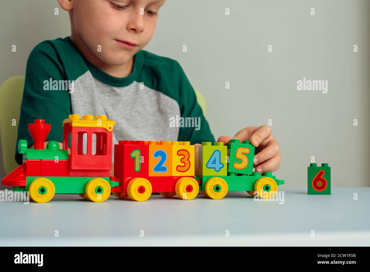 Child playing with a train, blocks of numbers. Educational toys for ...