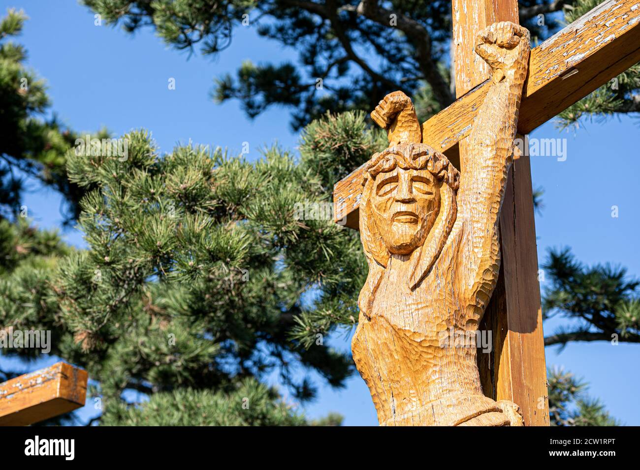 wooden crucifixion in sunlight in front of trees Stock Photo - Alamy