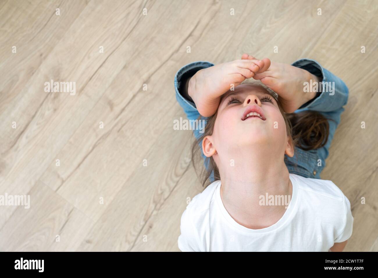 Girl child practicing yoga at home, stretching in raja bhudjangasana ...