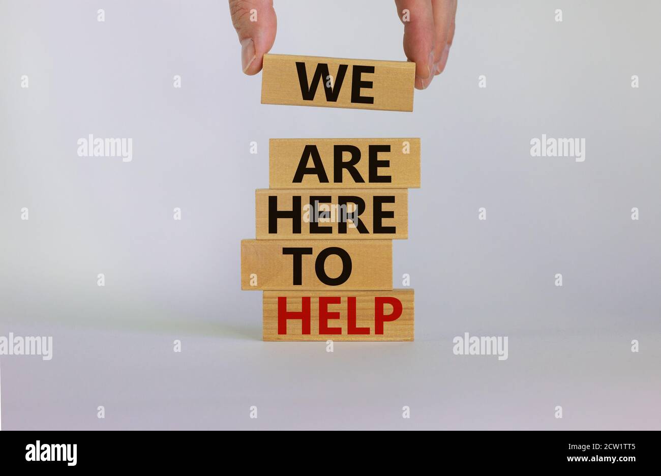 Wooden blocks with text 'we are here to help'. Male hand. Beautiful ...