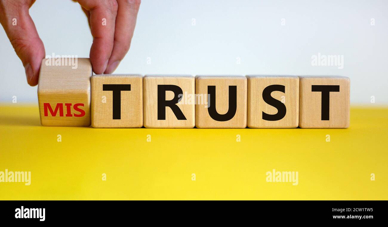 Hand turns a cube and changes the expression 'mistrust' to 'trust ...