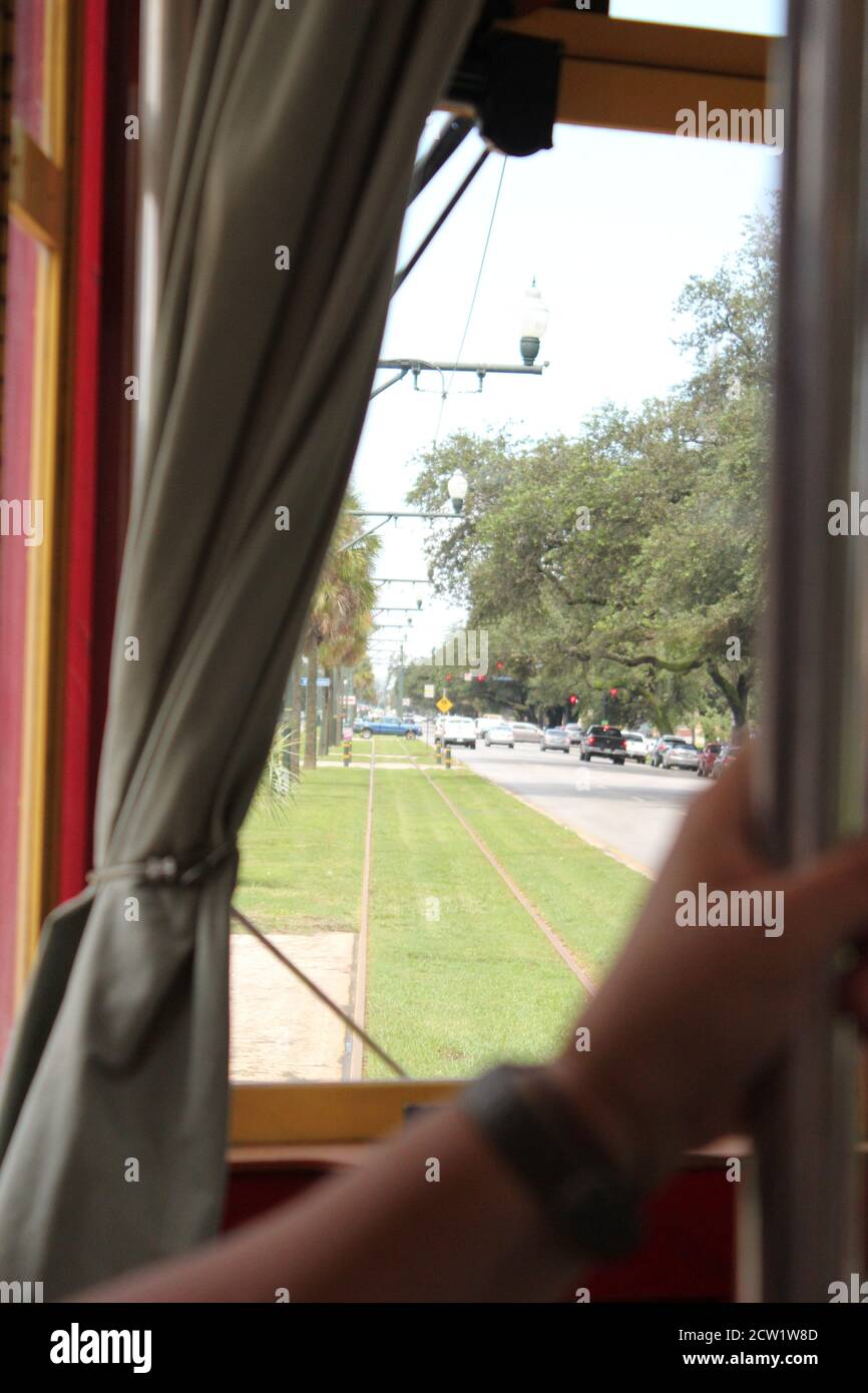 View out of trolley window with hand New Orleans Stock Photo - Alamy