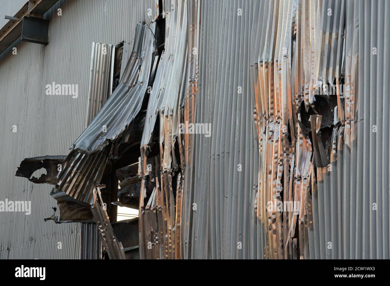 Close up view on damaged aluminium corrugated plate after fire as part ...