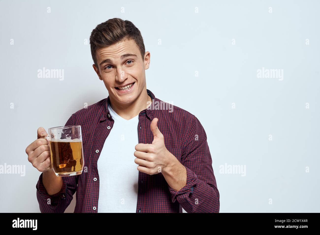 Drunk man with a mug of beer vacation alcohol lifestyle in a red shirt ...