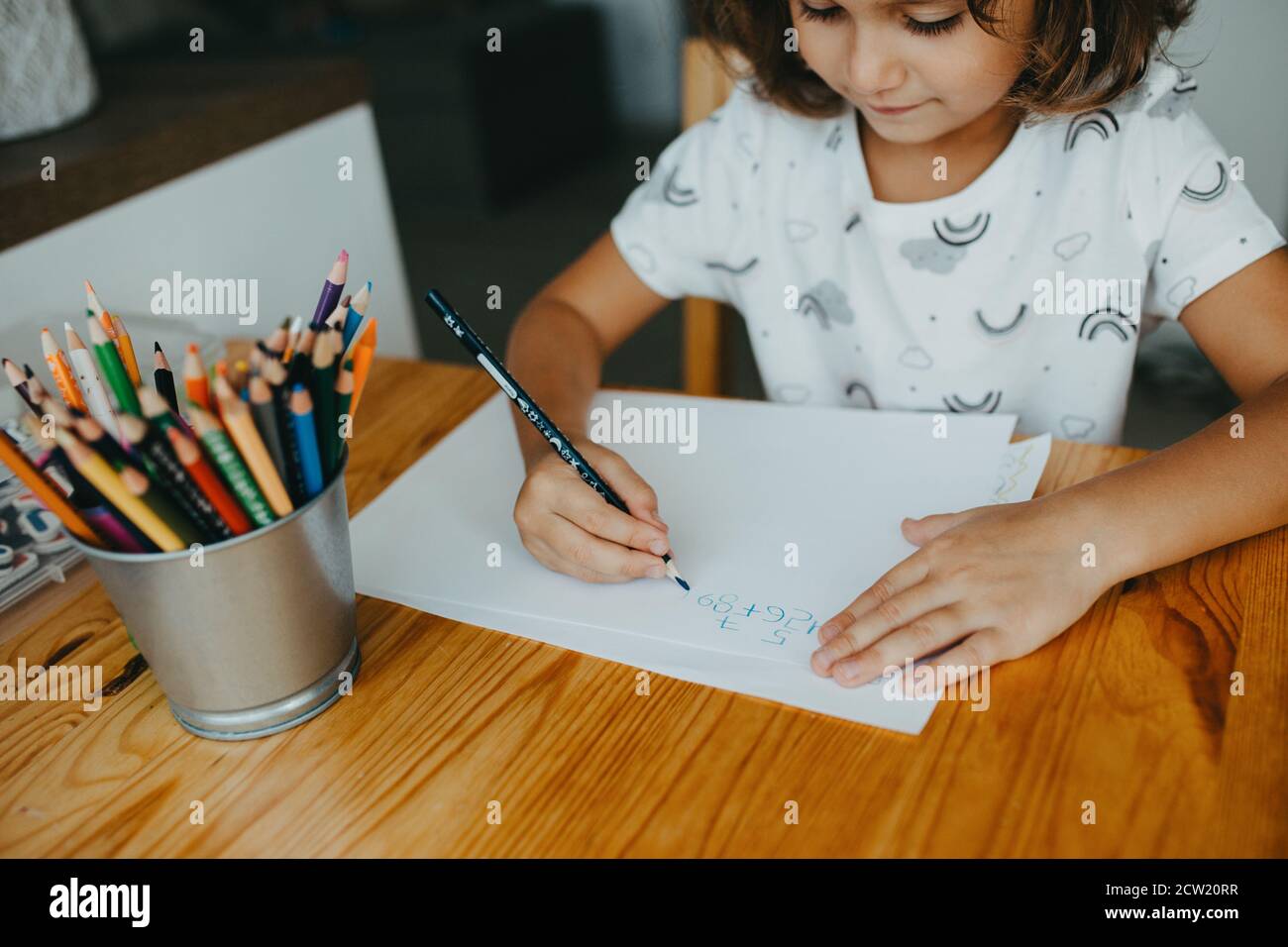 Cute five years girl doing maths writing numbers at home. Education and ...