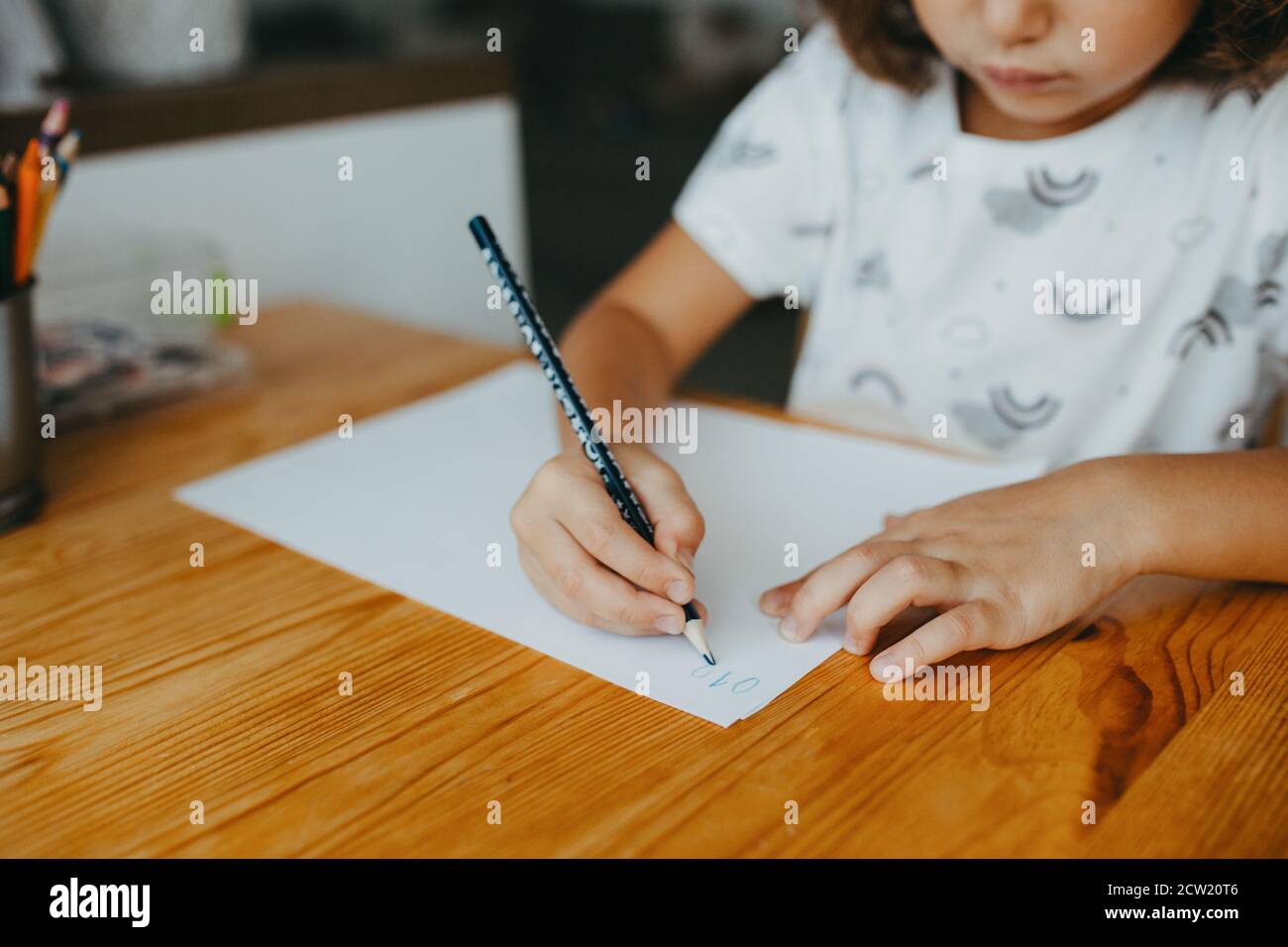 Cute five years girl doing maths writing numbers at home. Education and ...
