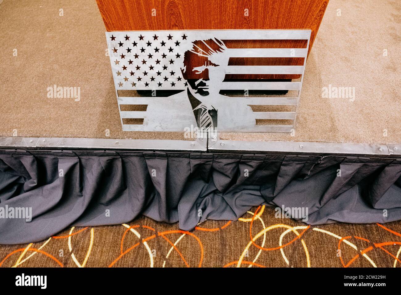 a laser-cut steel Trump sign decorates the podeum of the Mesa County ...