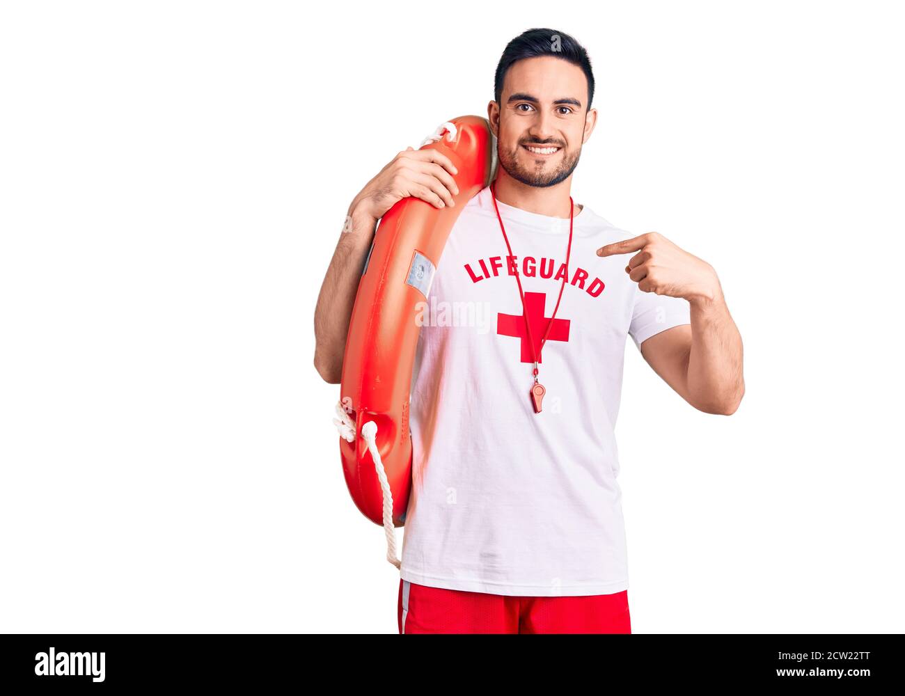 Young handsome man wearing lifeguard uniform holding float pointing ...