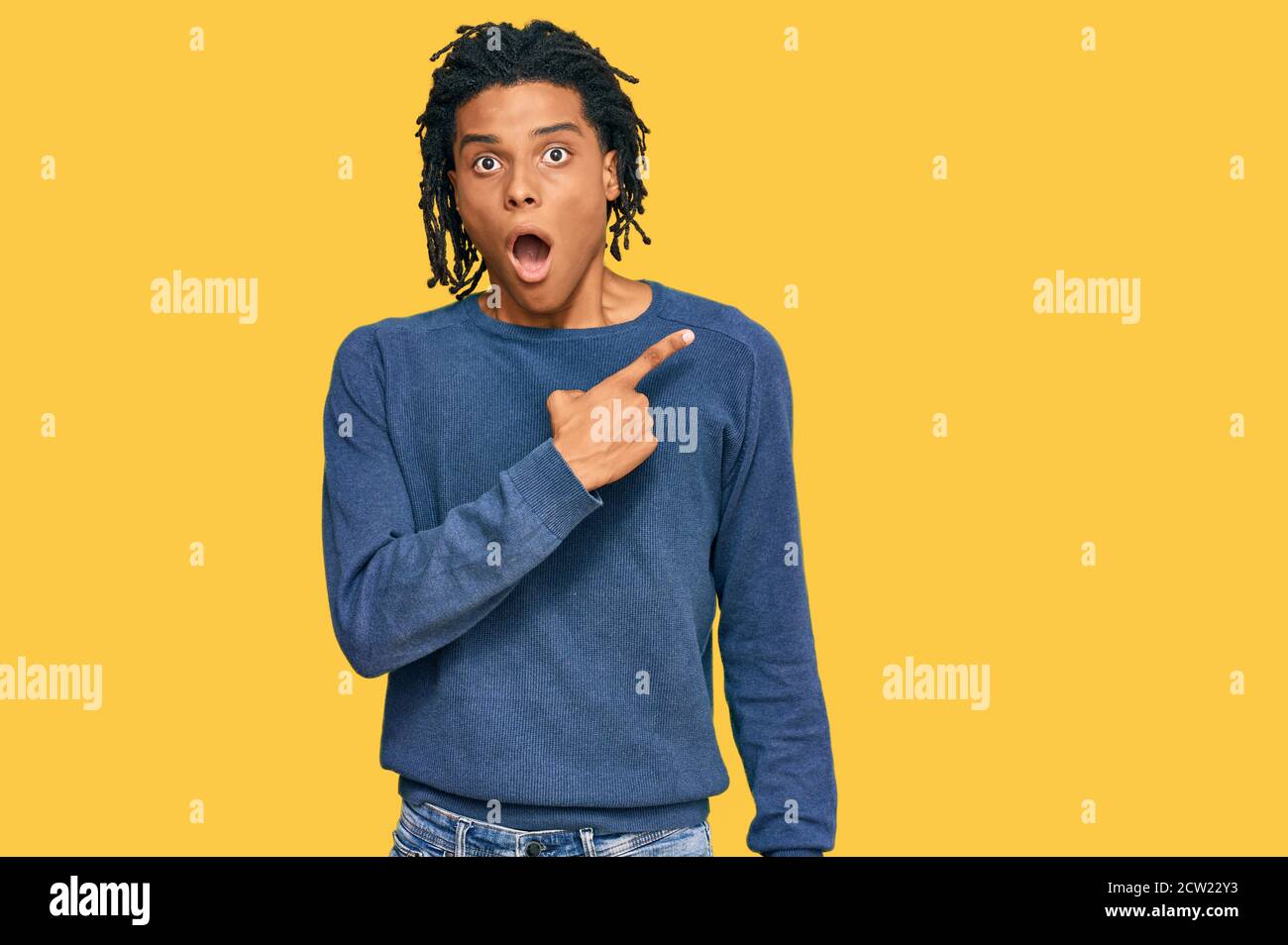 Young african american man wearing casual winter sweater surprised ...
