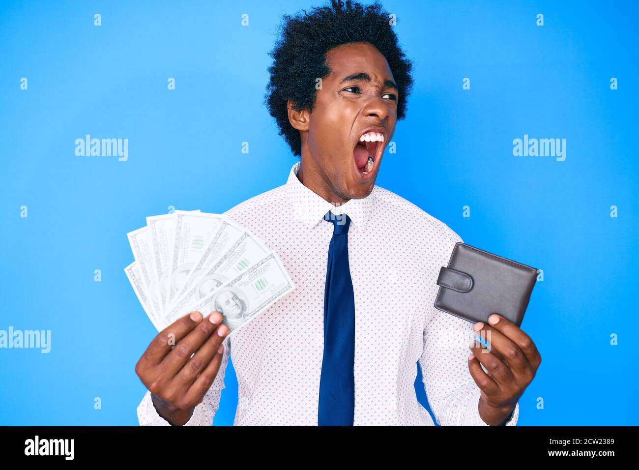 Handsome african american man with afro hair holding wallet and dollars ...