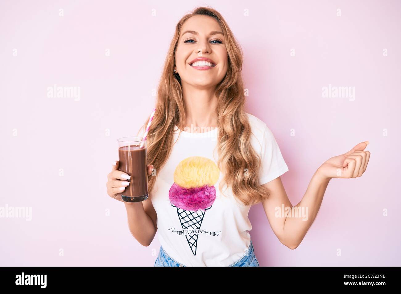 Young caucasian woman with blond hair drinking chocolate milkshake ...