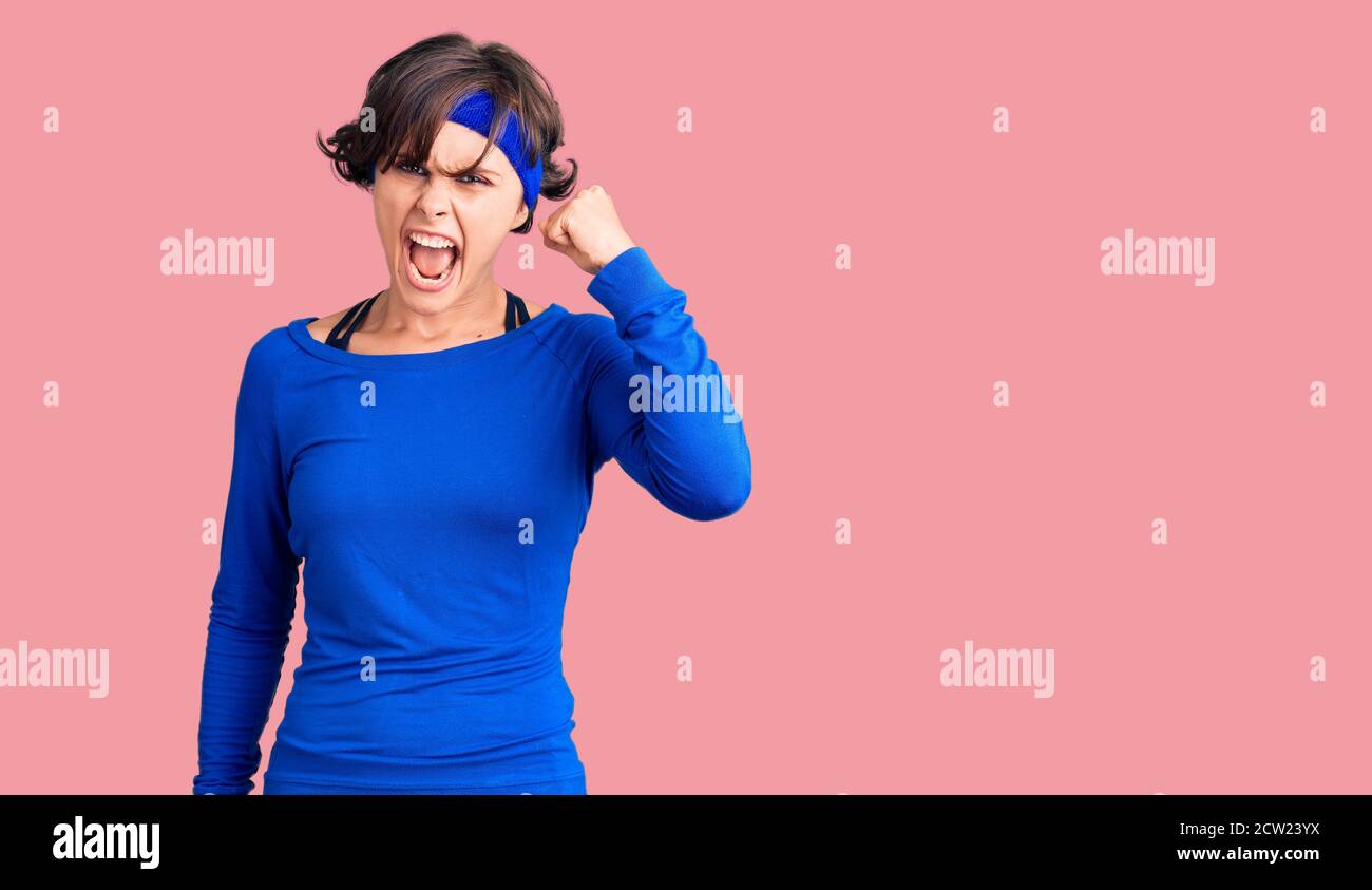 Beautiful young woman with short hair wearing training workout clothes ...