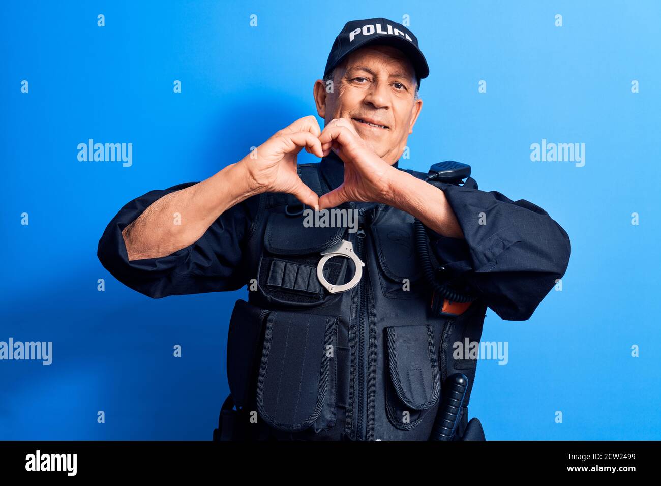 Senior man with grey hair wearing police uniform smiling in love doing ...