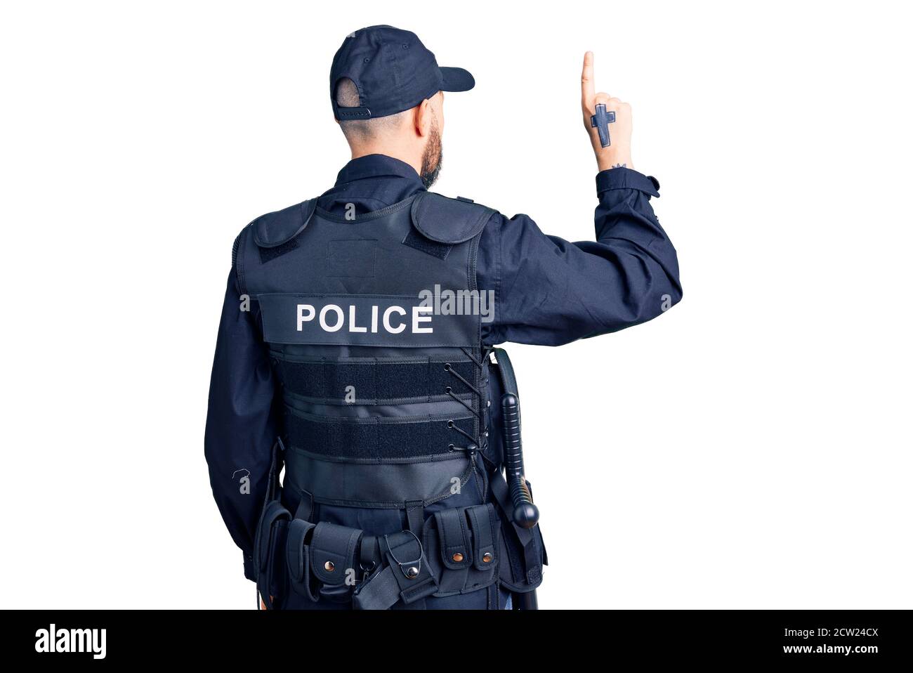 Young handsome man wearing police uniform posing backwards pointing ...