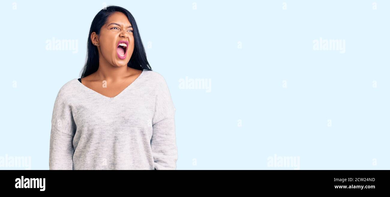 Hispanic woman with long hair wearing casual clothes angry and mad ...