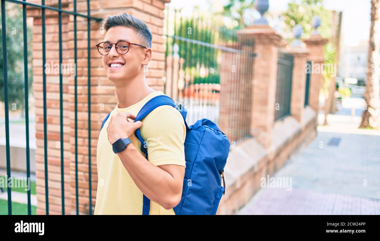 Young hispanic student smiling happy walking at street of city Stock ...
