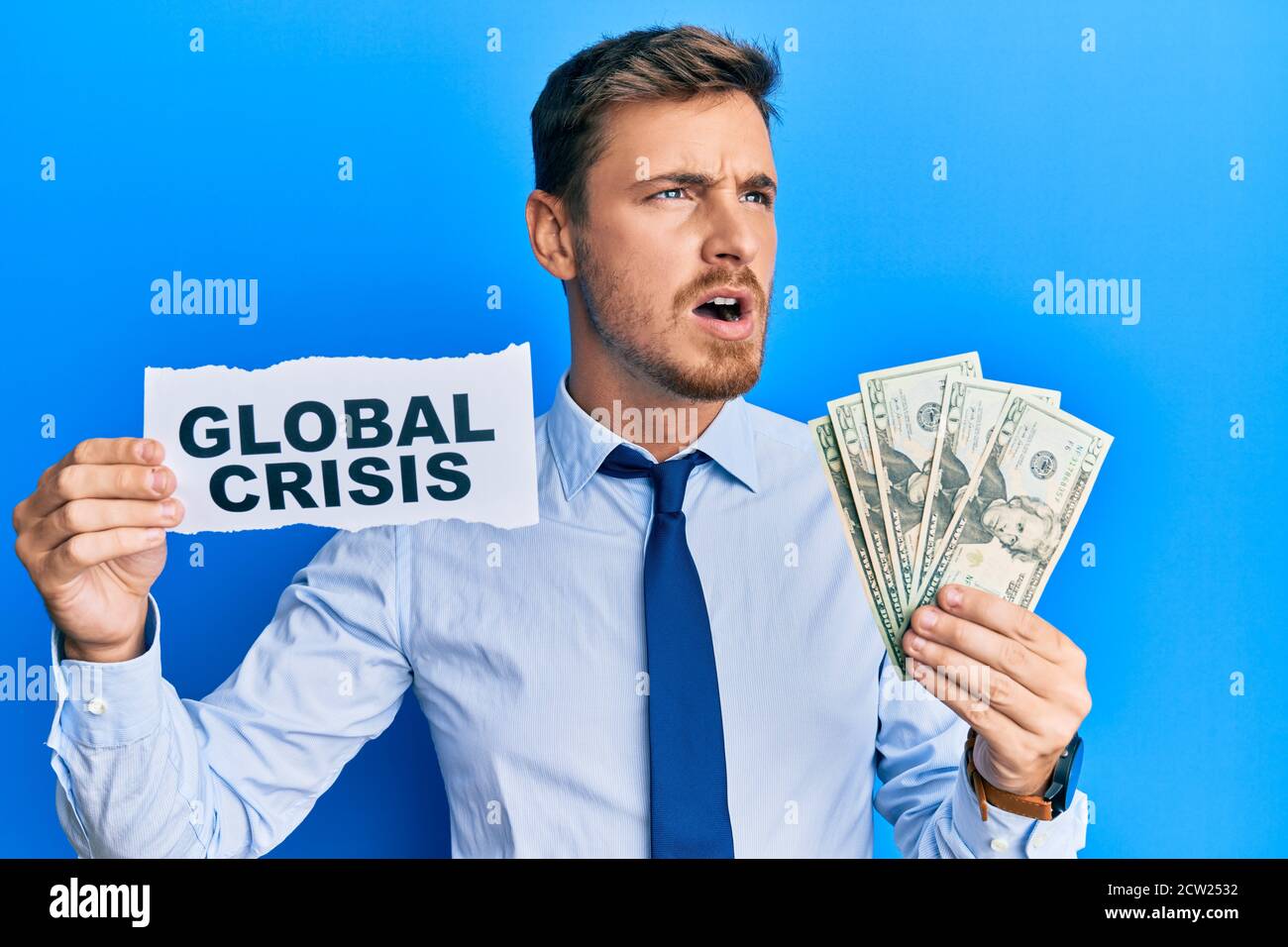 Handsome caucasian business man holding dollars on global crisis angry ...